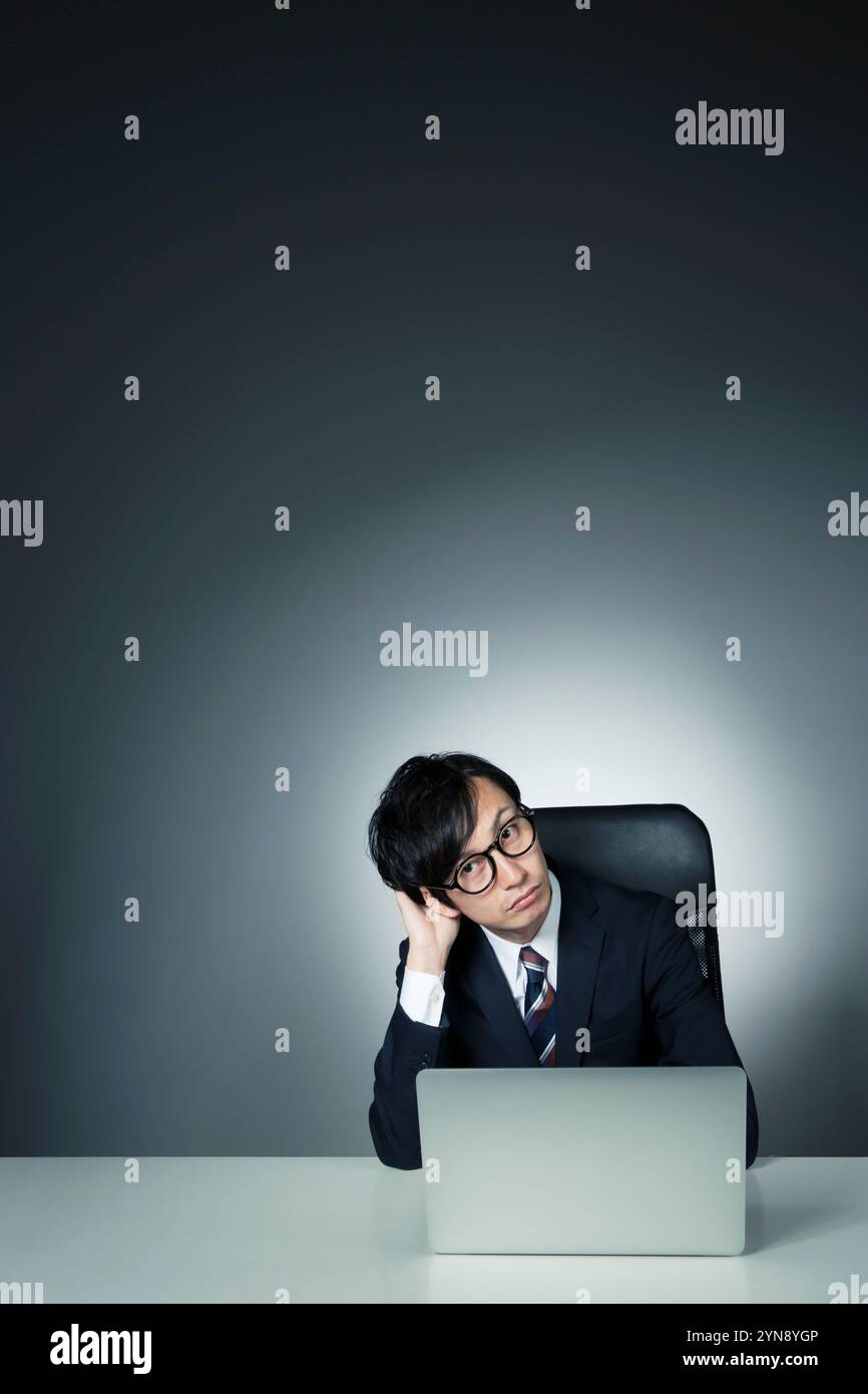 Man in his 20s thinking in front of a computer Stock Photo - Alamy