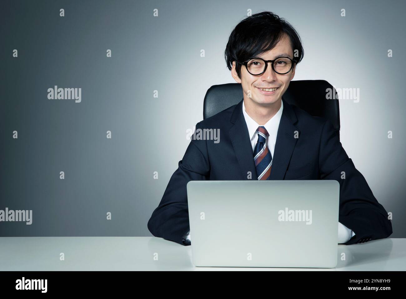 Male in his 20s looking at the camera as he places his computer in ...