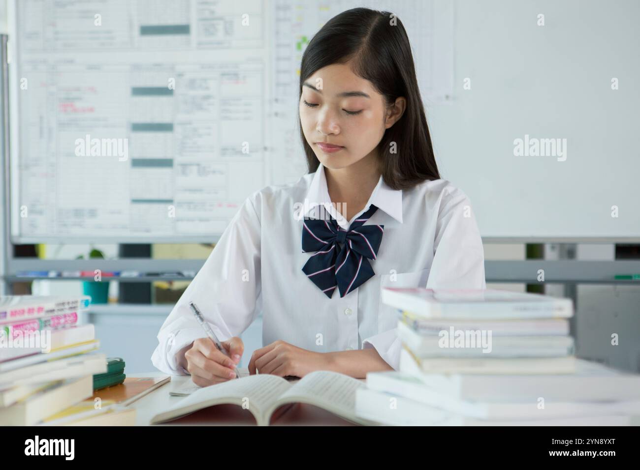 High school girl studying among piles of books Stock Photo - Alamy