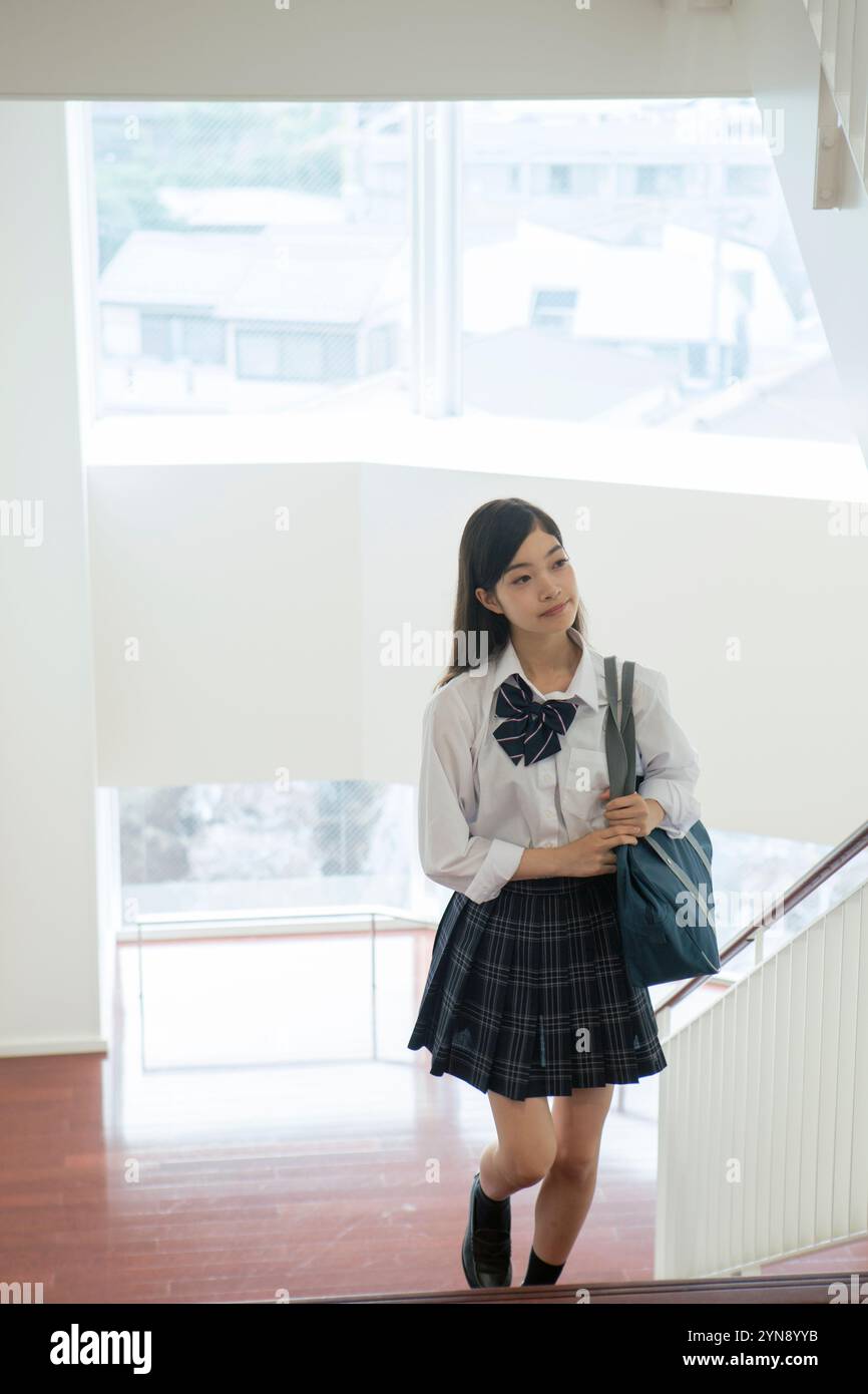 Smiling high school girl ascending corridor stairs Stock Photo - Alamy