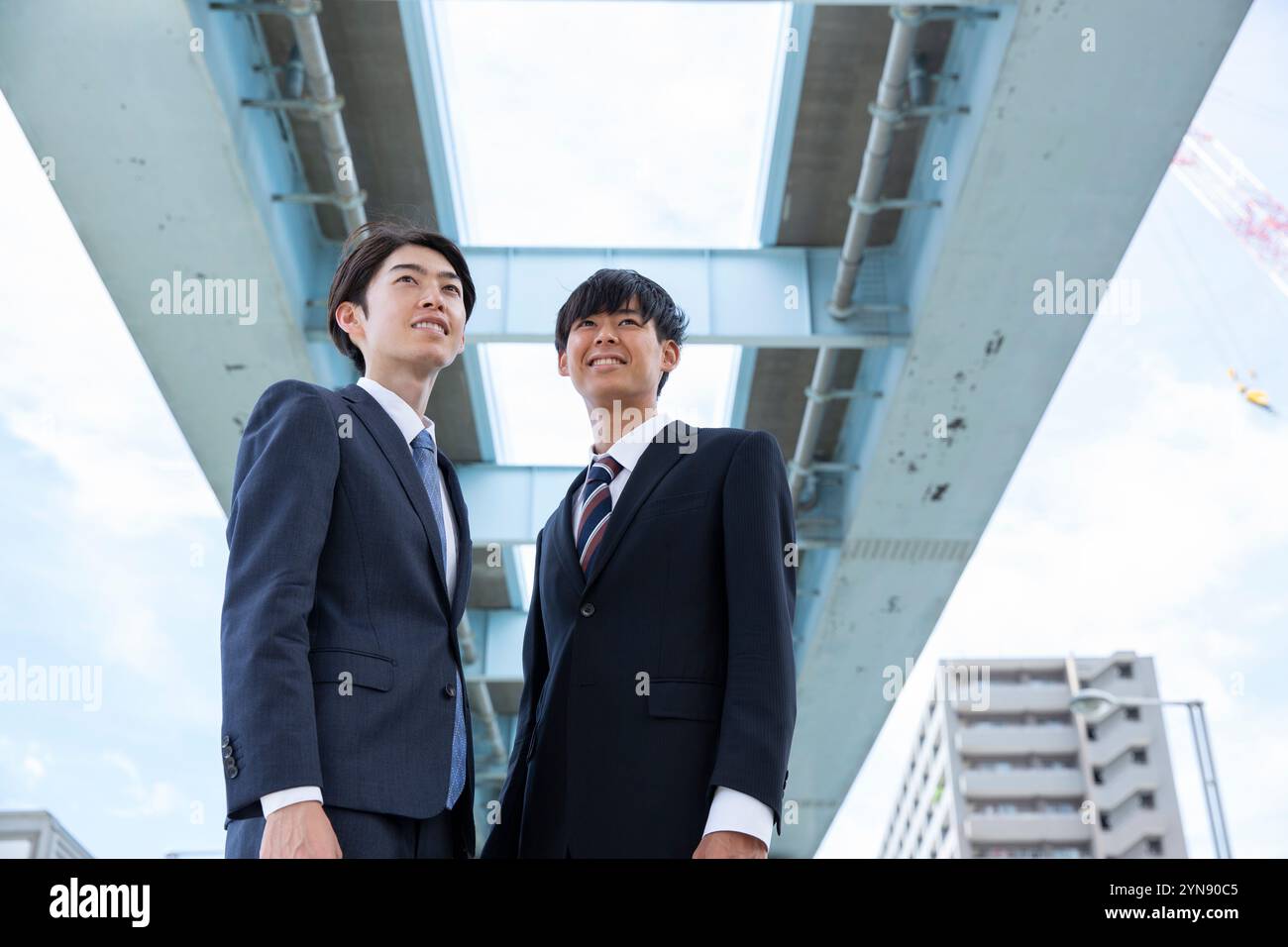 Two men in their 20s in suits standing outdoors Stock Photo - Alamy