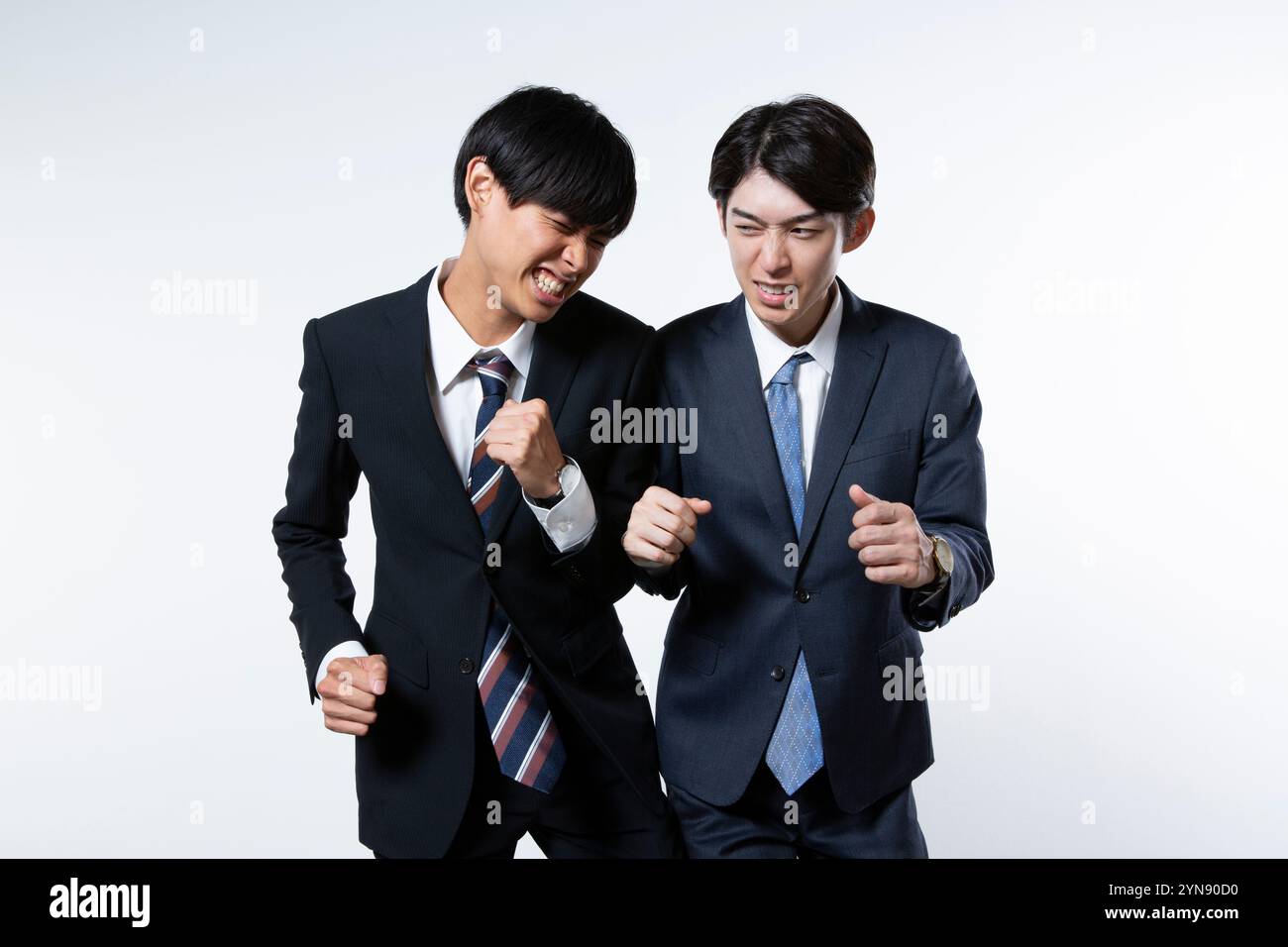 Portrait of two men in their 20s in suits running to work Stock Photo ...
