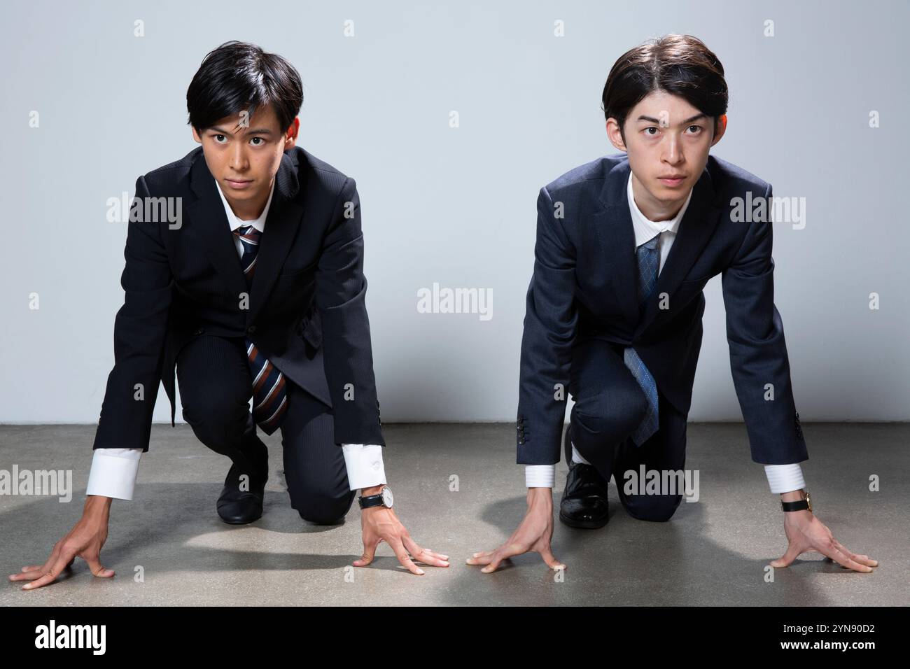 Portrait of two men in their 20s in suits running to work Stock Photo ...