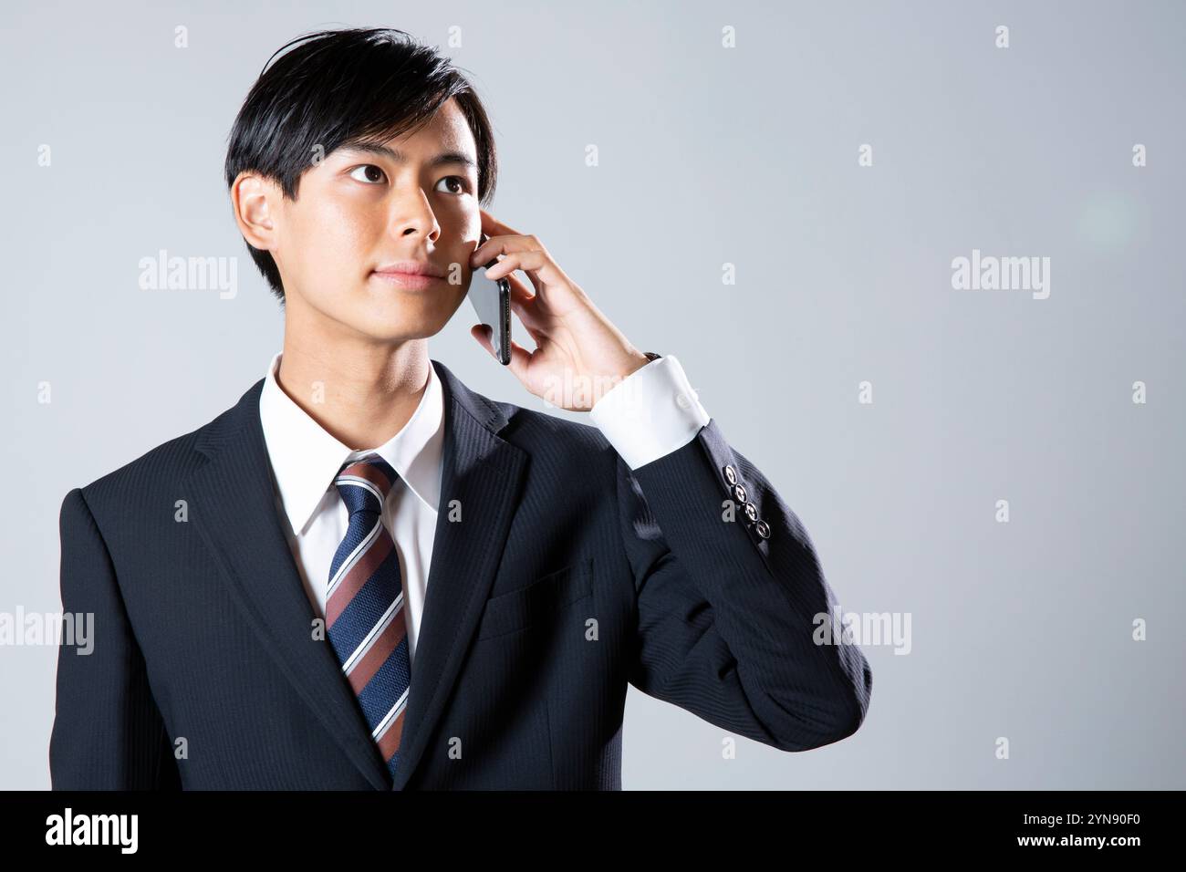 Man in his 20s in a suit making a phone call Stock Photo - Alamy