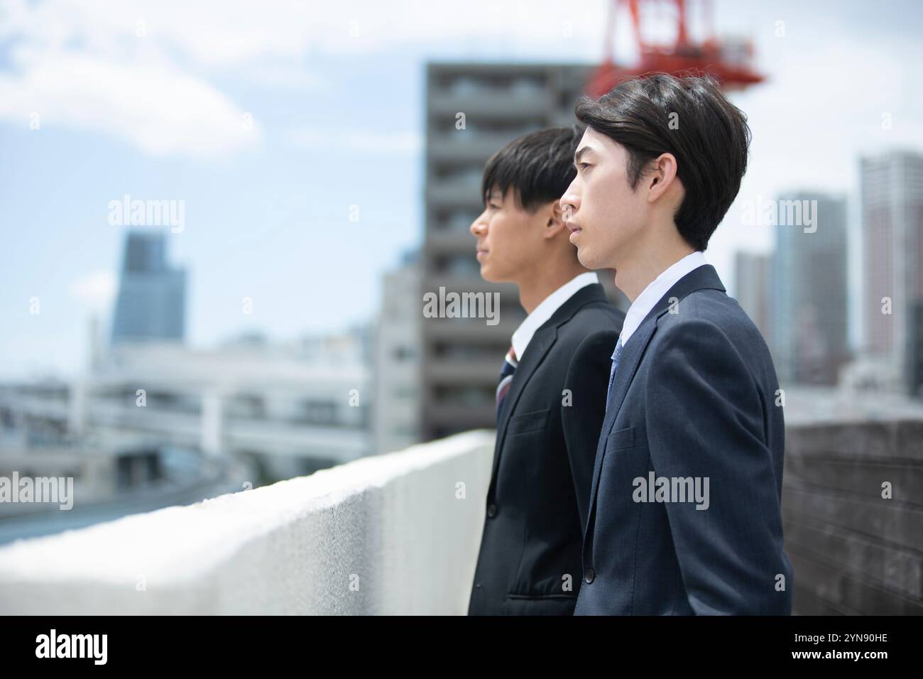 Two men in their 20s in suits standing on the rooftop Stock Photo - Alamy