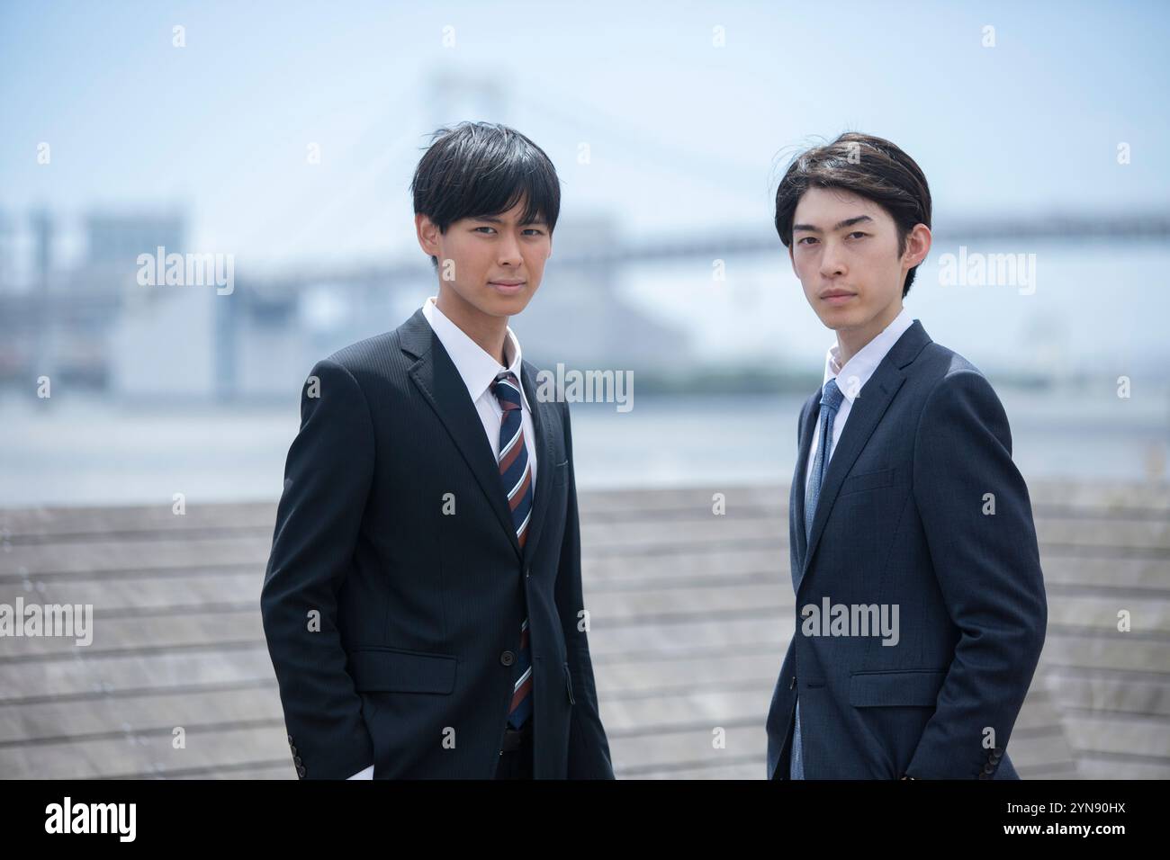 Two men in their 20s in suits standing on the rooftop Stock Photo - Alamy