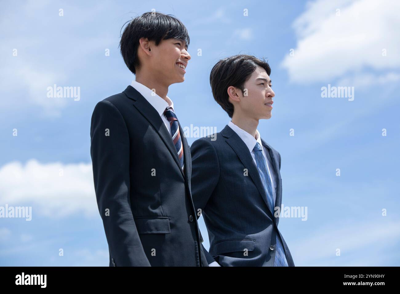 Two men in their 20s in suits standing on the rooftop Stock Photo - Alamy