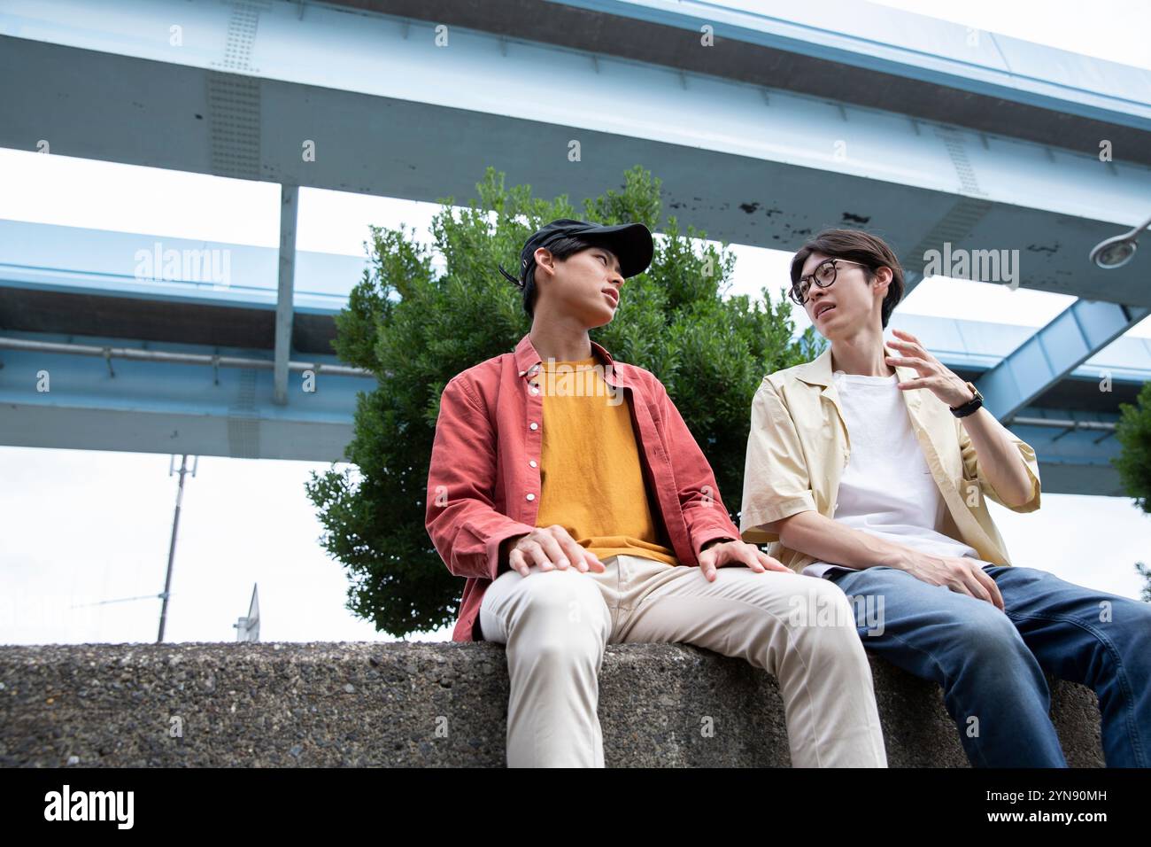 Two men in their 20s talking outdoors Stock Photo - Alamy