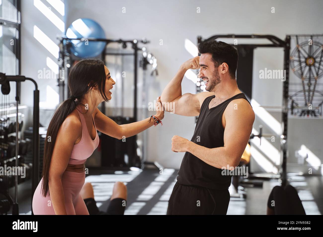 Fitness man showing his arm muscle to female partner after exercising ...