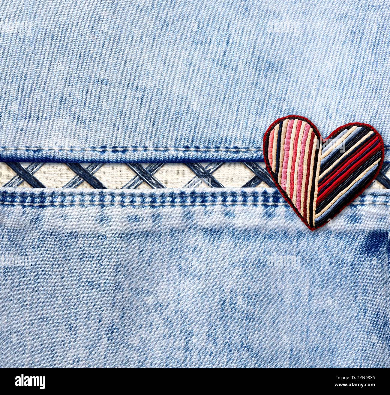 Light blue denim background with a seam and felt heart in patchwork ...