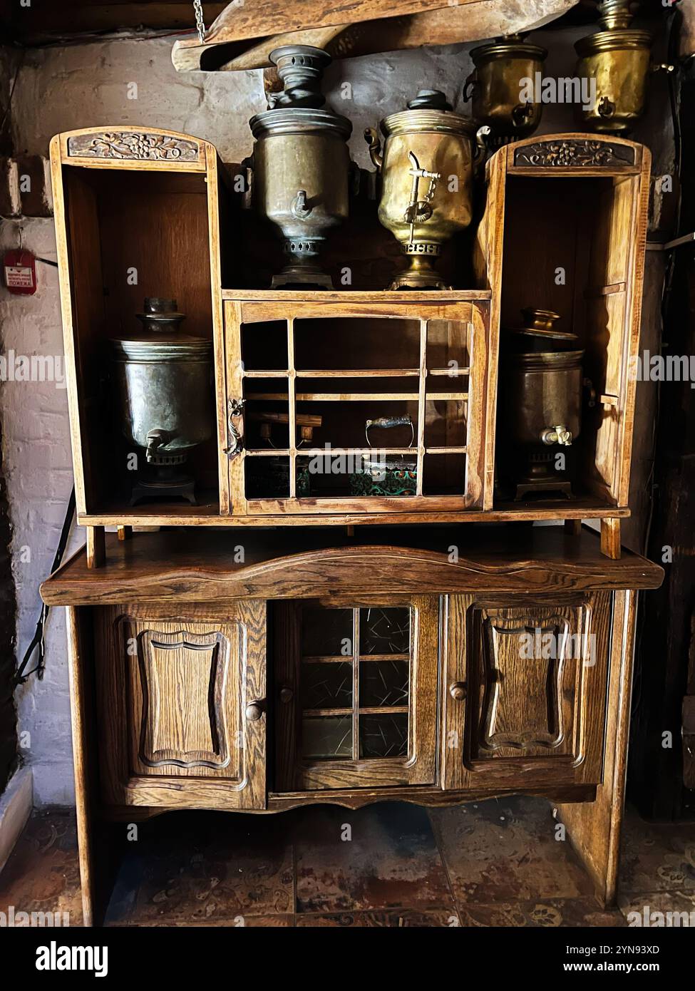 A collection of antique samovars is elegantly displayed on a rustic ...