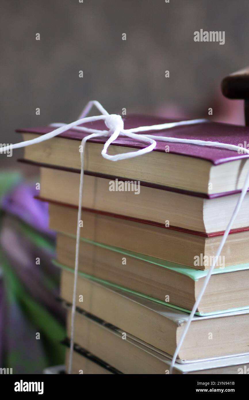 A neatly stacked collection of books held together tightly with a ...
