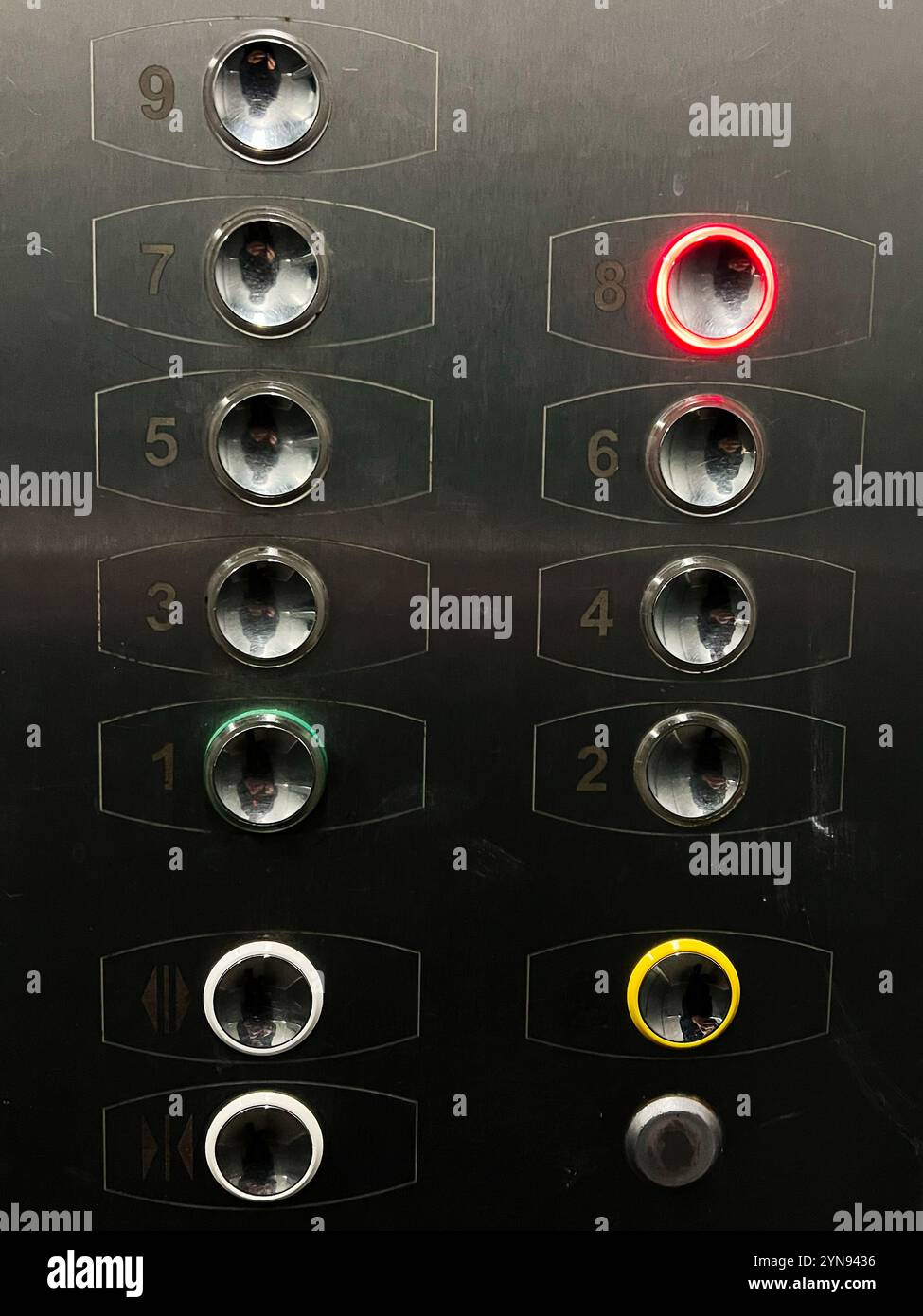 A detailed image of an elevator control panel with buttons highlighted ...