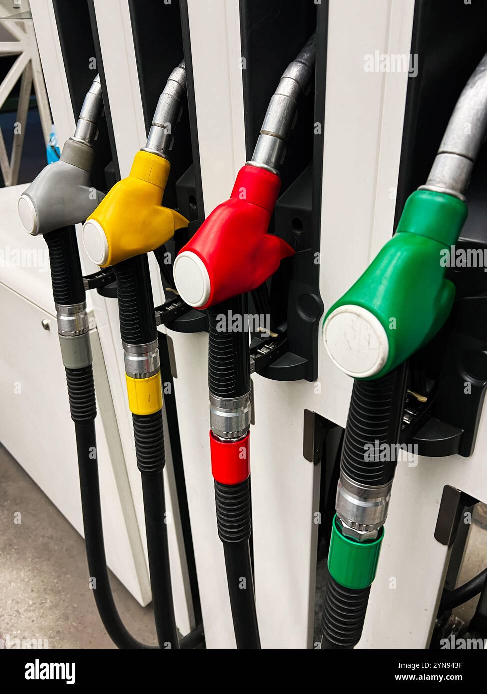 Close-up view of vibrant fuel pump handles at a gas station. The image ...