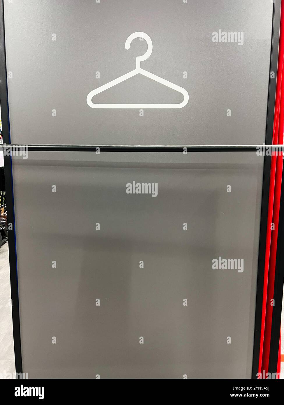 A simple white hanger symbol adorns a gray changing room door ...