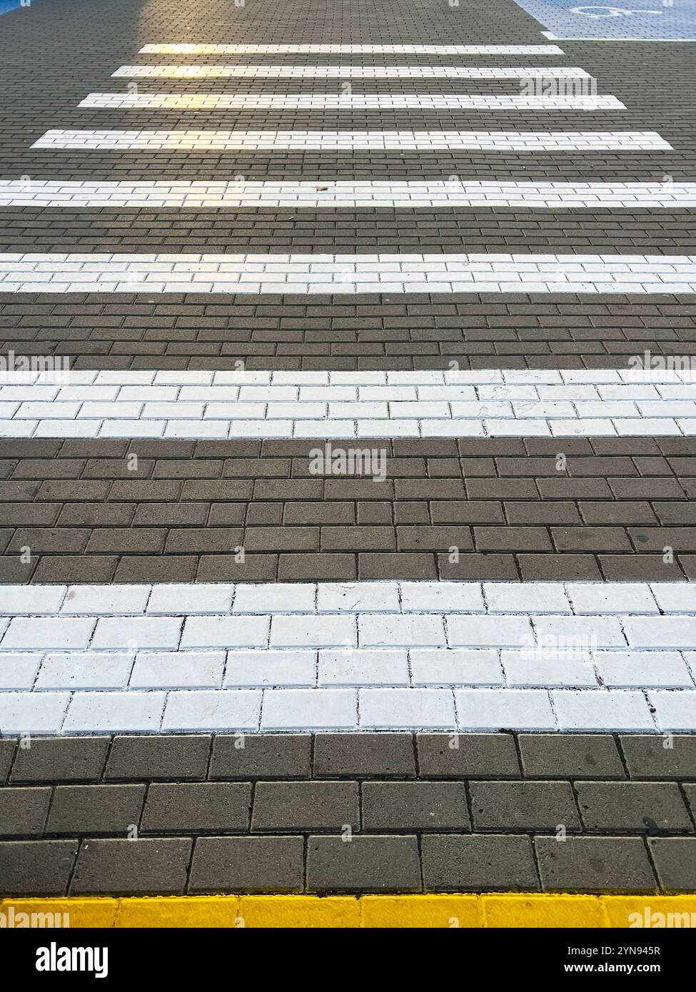 A detailed view of a pedestrian crosswalk on a brick pavement ...
