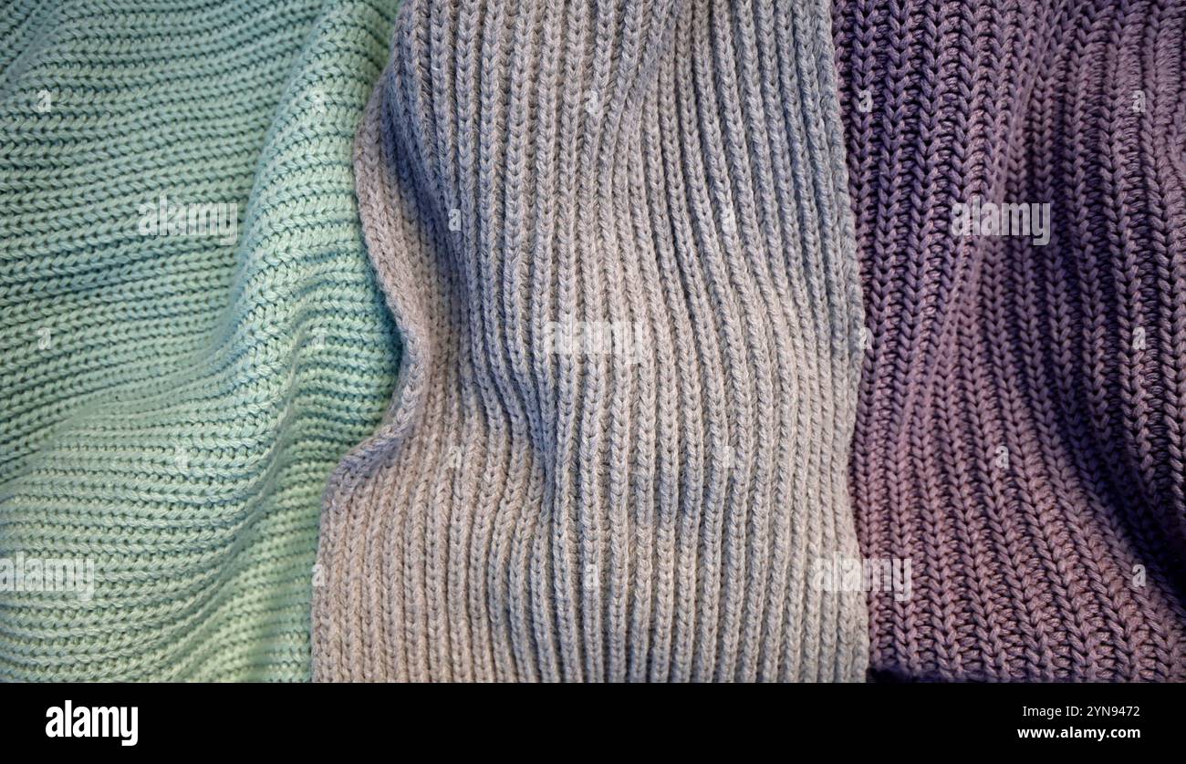 Background is filled with knitted fabric of gray, turquoise, purple ...