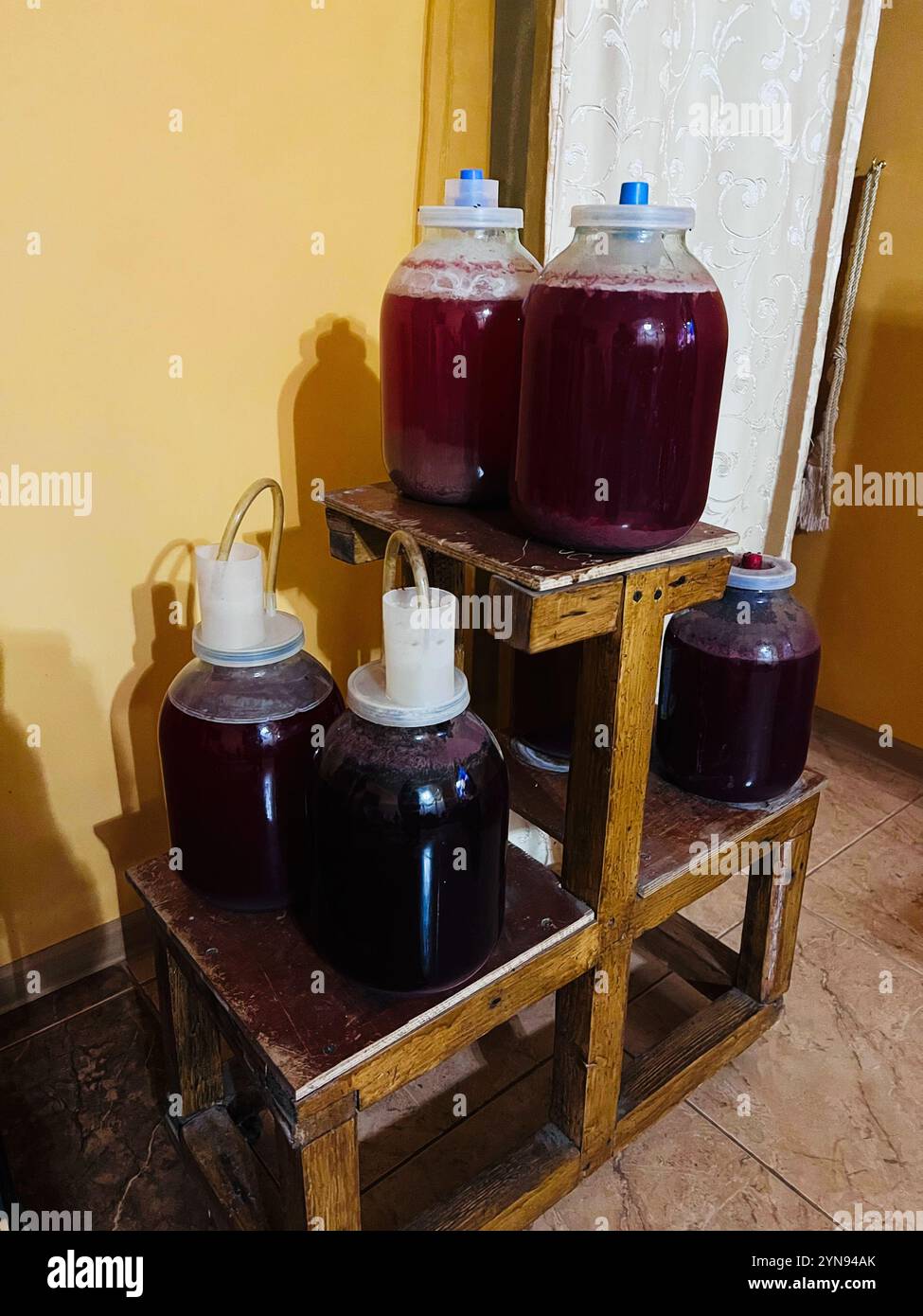 Glass jars filled with homemade fermenting liquid, placed on a rustic ...