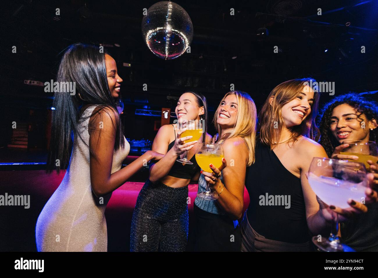 A lively group of friends enjoy a night out, dancing and celebrating ...