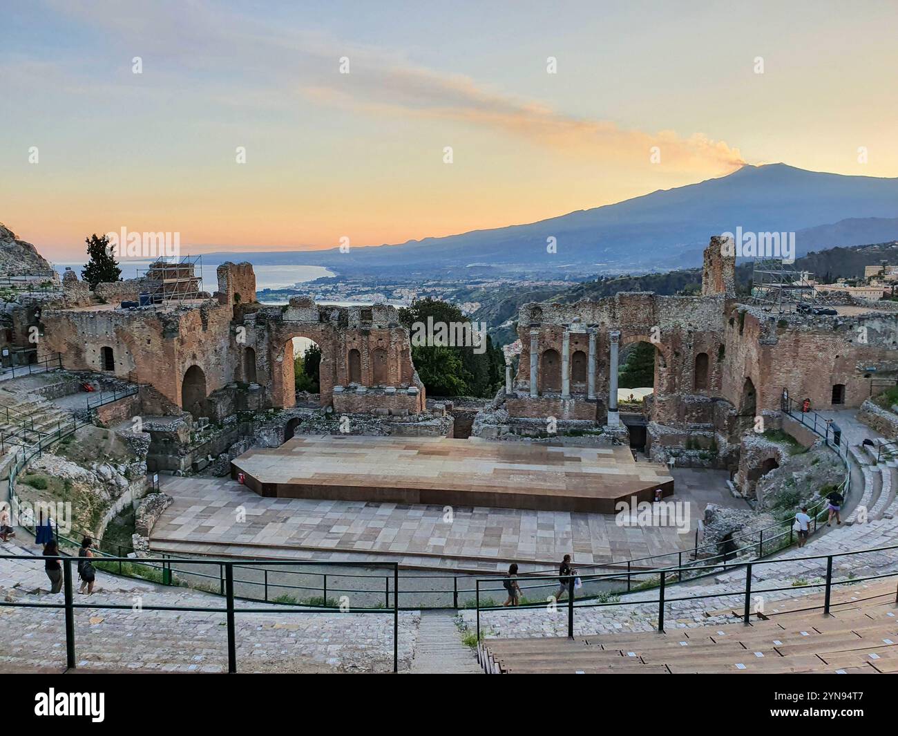 As the sun sets over Taormina, the ancient Greek theater stands proudly ...
