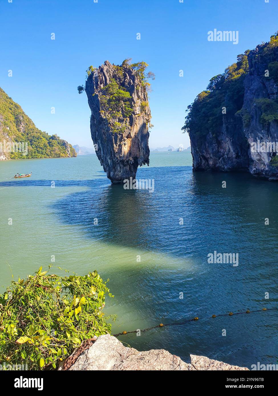 Towering limestone cliffs stand sentinel over tranquil waters while a ...