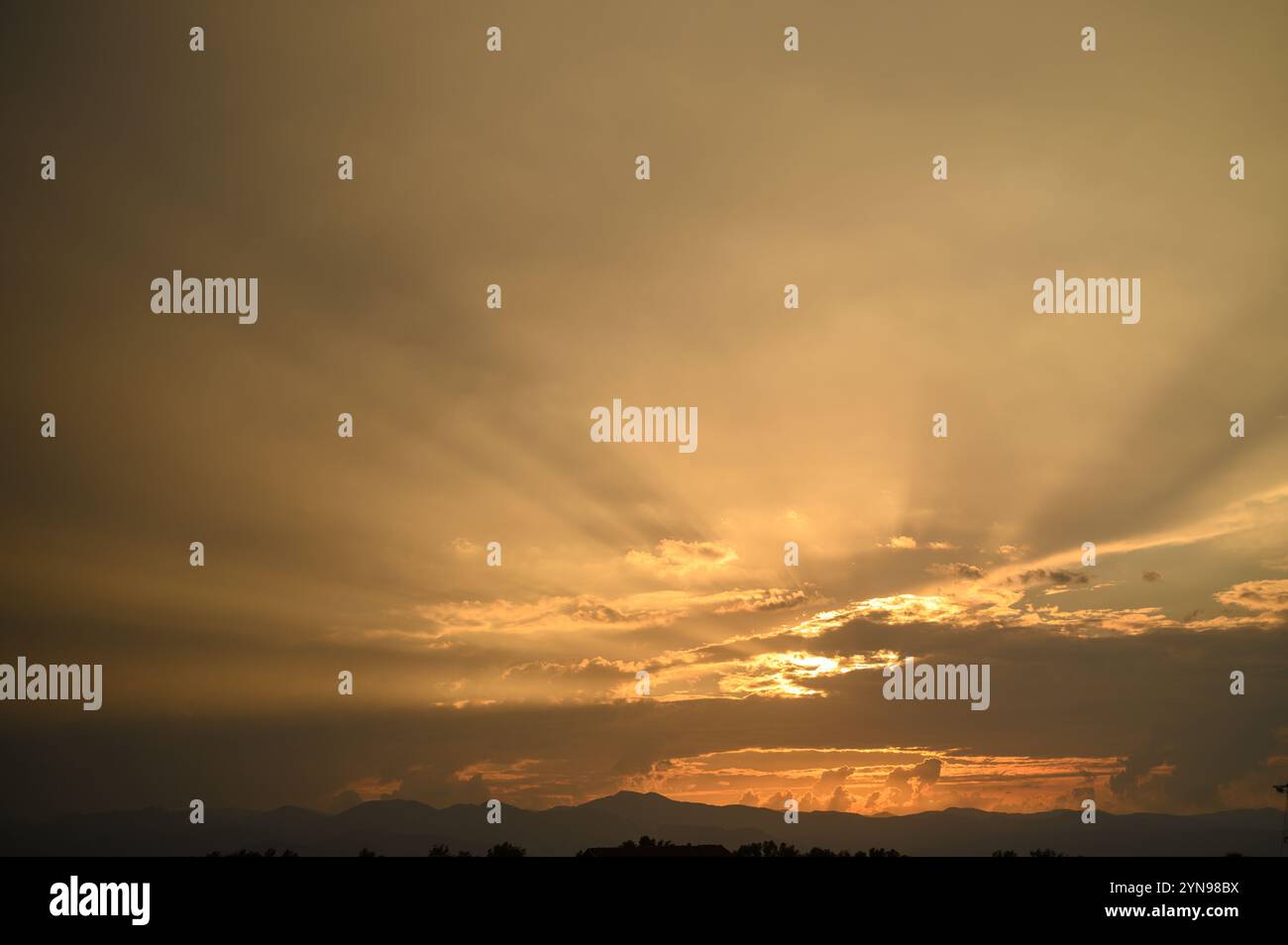 A breathtaking sunset casts golden light as clouds drift, creating a ...