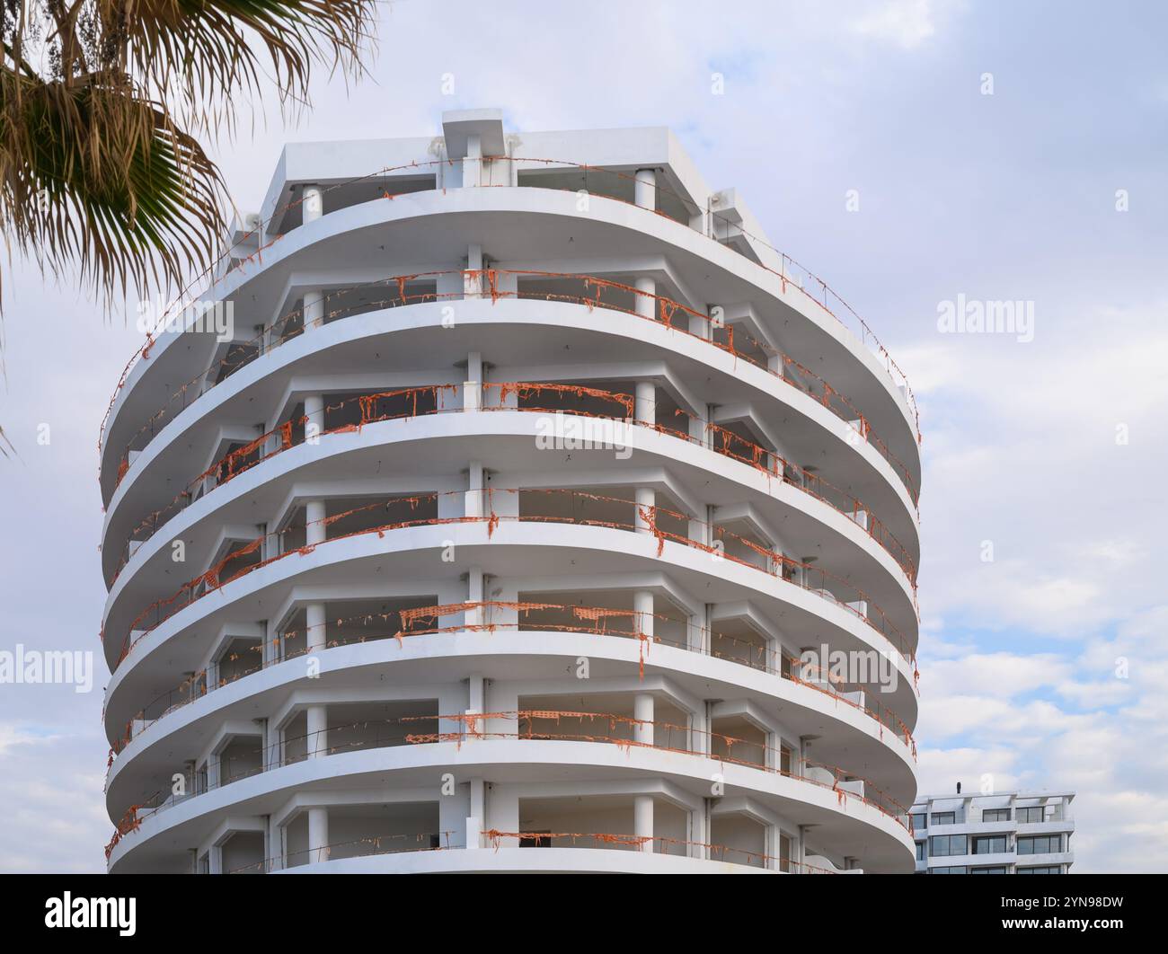 A contemporary building features smooth curves and multiple balconies ...