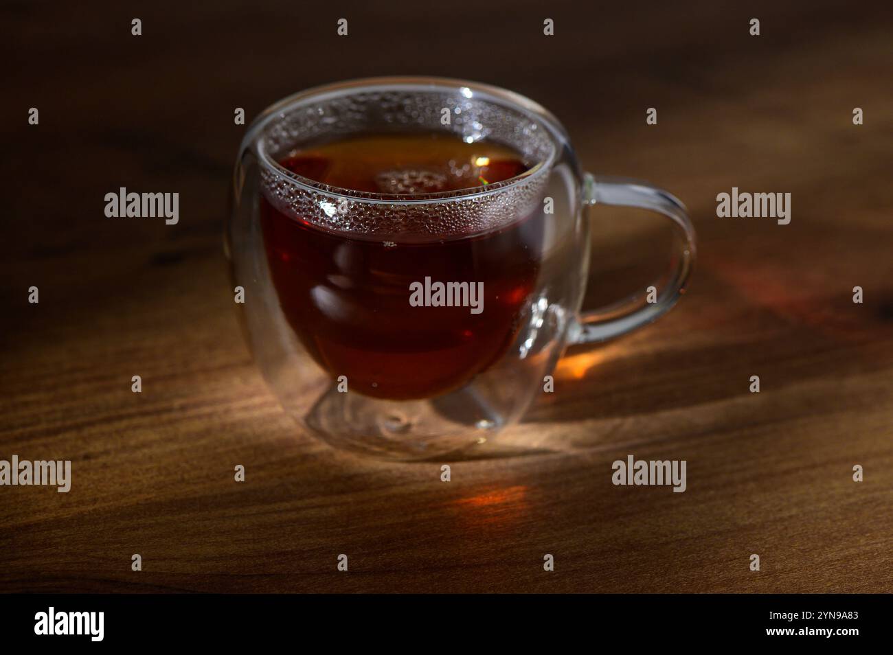 The rich aroma of freshly brewed herbal tea fills the air as light ...