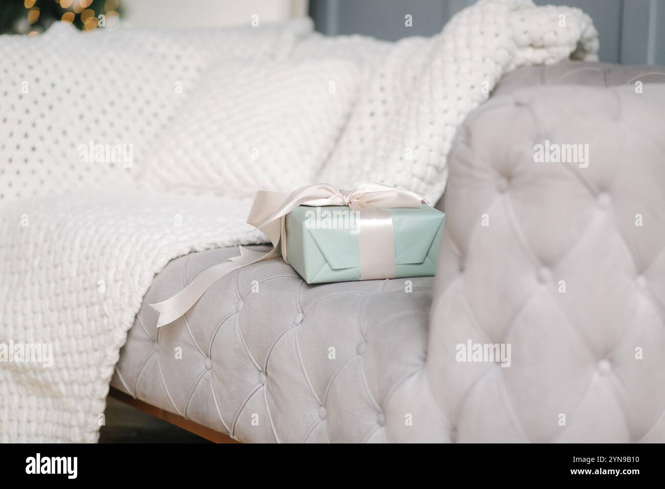 Little present stand on sofa at home. Christmas mood. Winter holiday ...