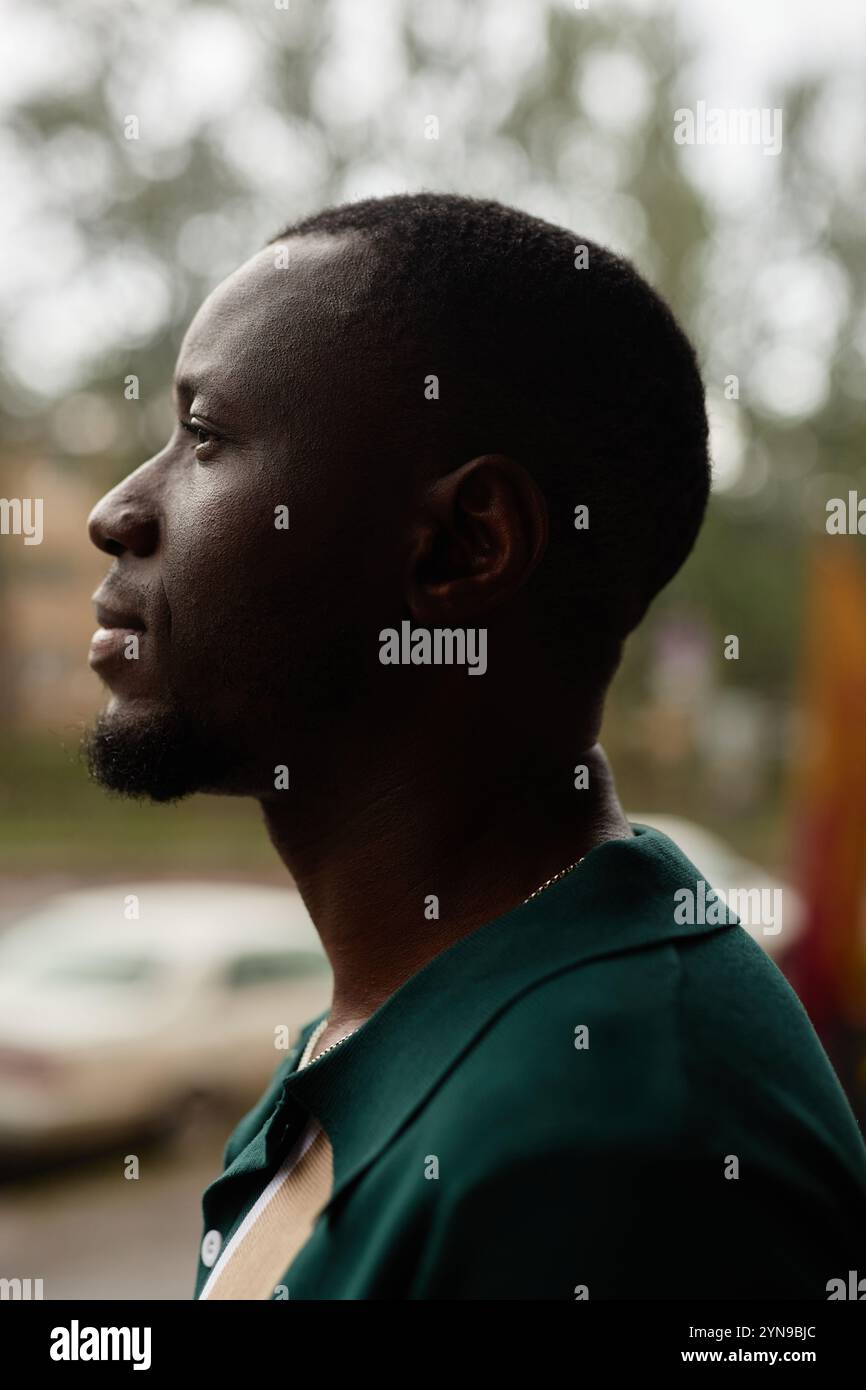 Vertical side view portrait of adult African American man standing in ...