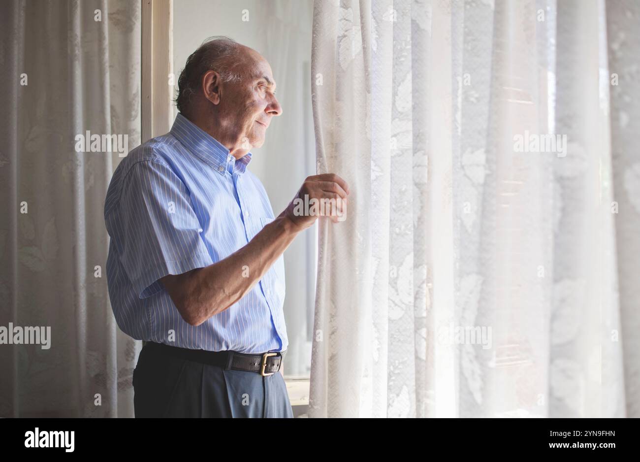 Elderly man stands alone window hi-res stock photography and images - Alamy