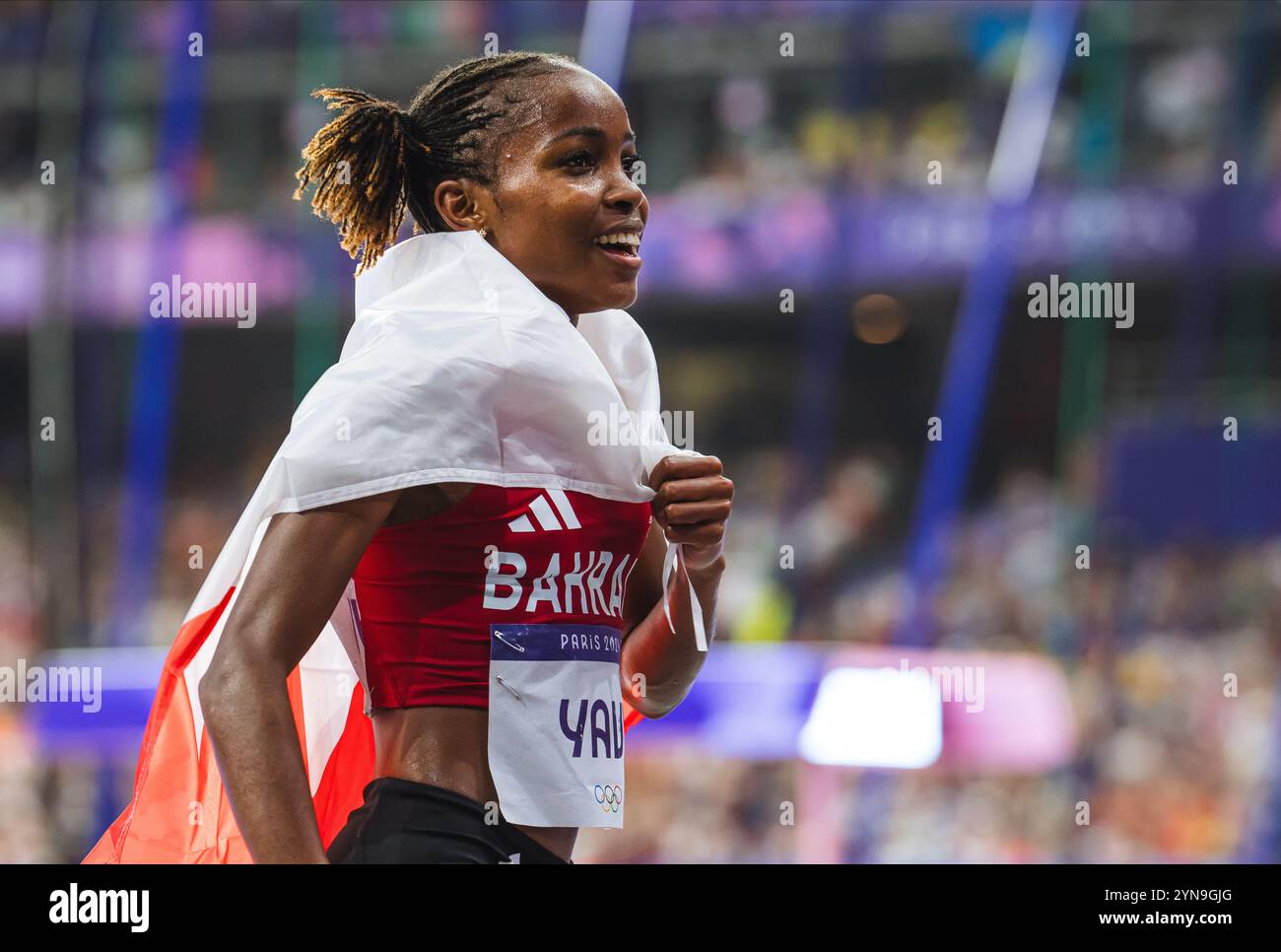 Winfred Yavi celebrating her medal with her country's flag at the Paris ...