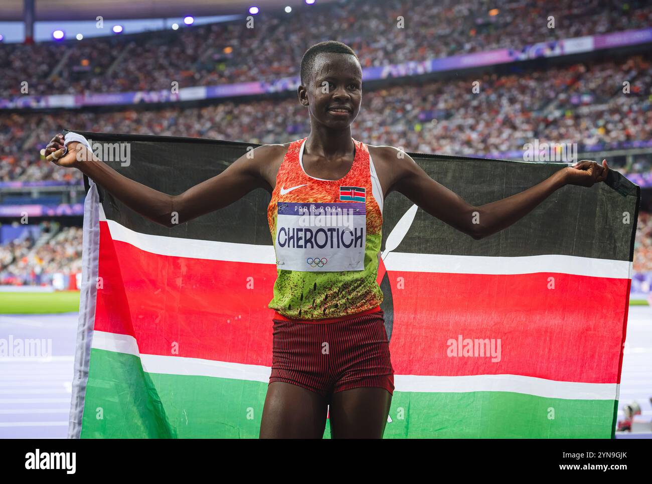 Faith Cherotich celebrating her medal with her country's flag at the ...