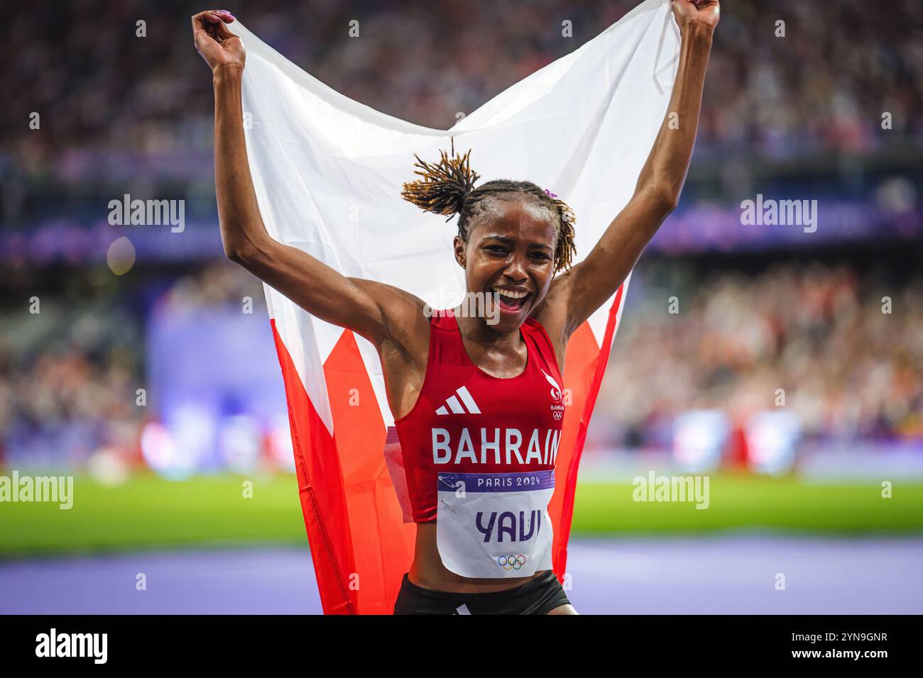 Winfred Yavi celebrating her medal with her country's flag at the Paris ...