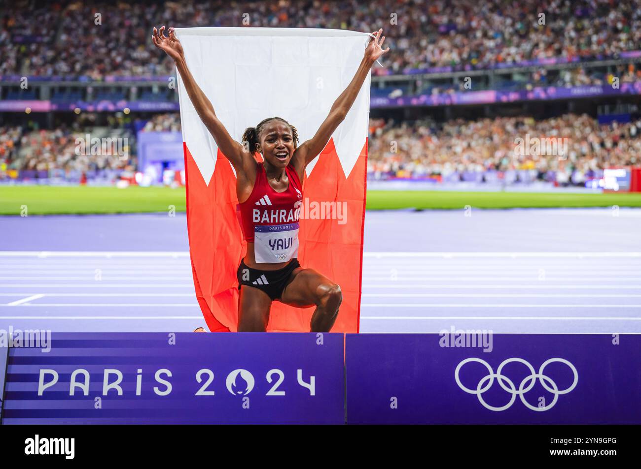 Winfred Yavi celebrating her medal with her country's flag at the Paris ...