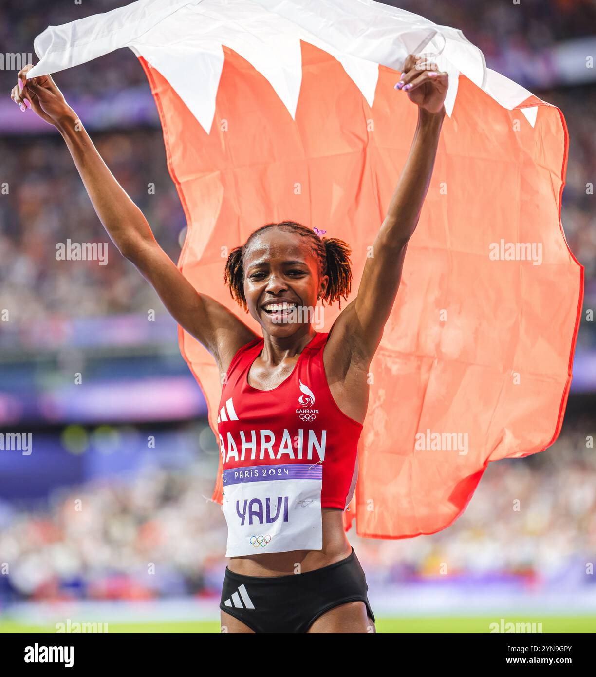 Winfred Yavi celebrating her medal with her country's flag at the Paris ...