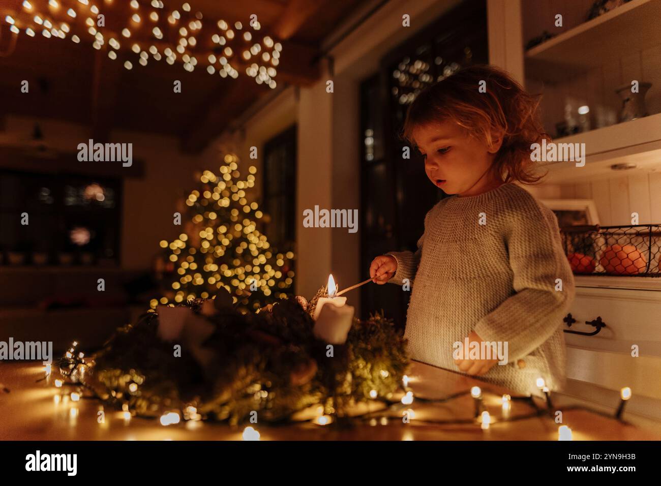 Little girl lighting candles on advent wreath Stock Photo - Alamy