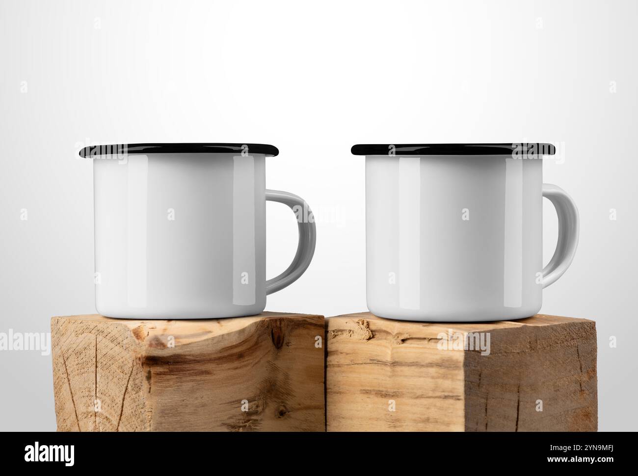 Mockup of two white enamel mugs with black rim, on old wooden beams ...