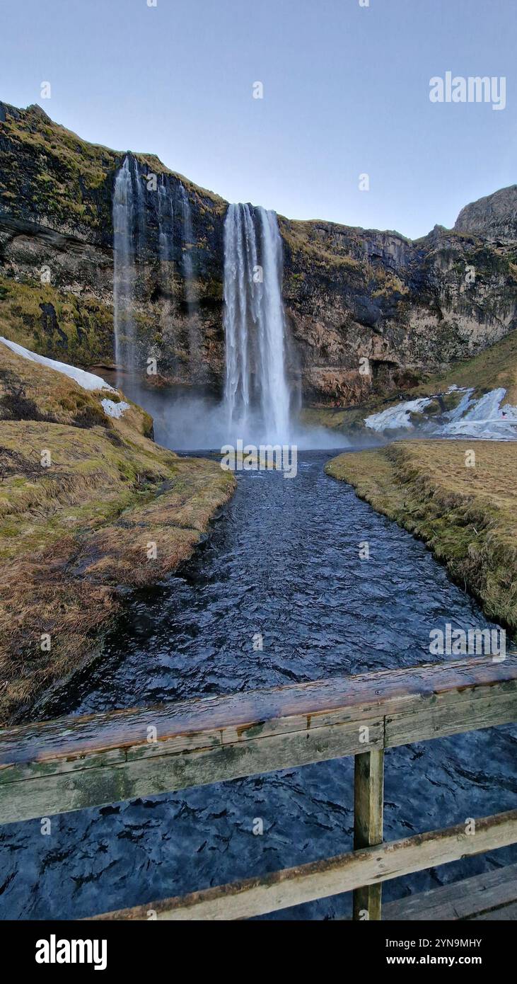 Natural cascade in icelandic wilderness with river flow running down ...