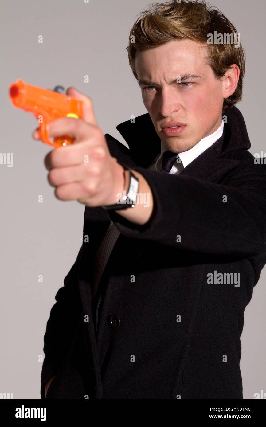 A male model aiming a toy gun during a photo shoot at a studio in Los ...