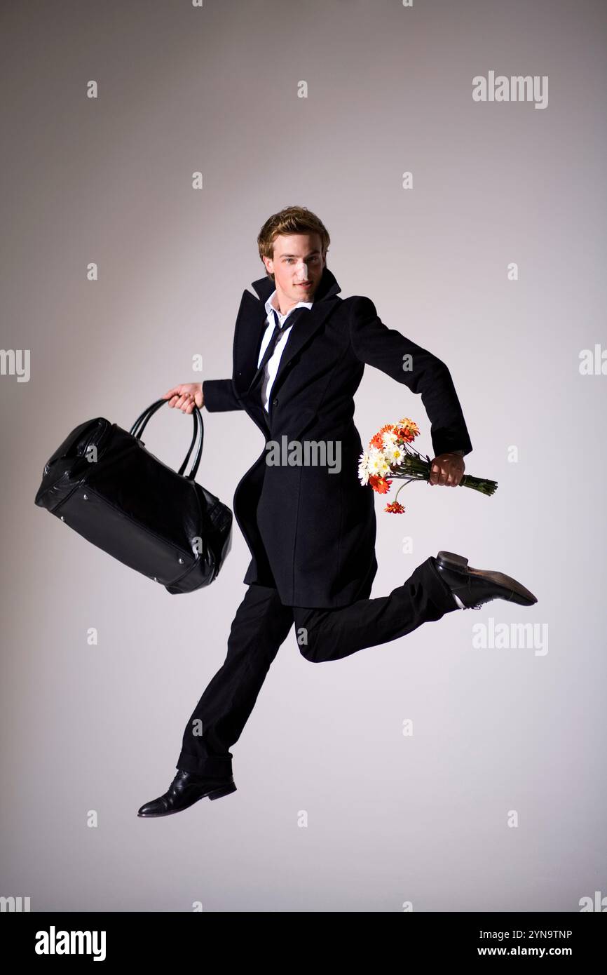A male model jumping in the air during a photo shoot at a studio in Los ...