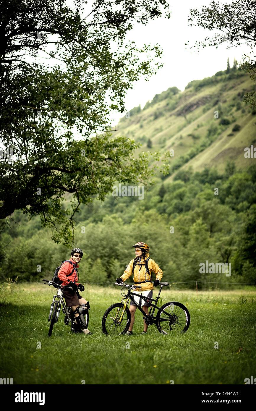 A man and woman mountain biking in the French Alps during the spring in ...