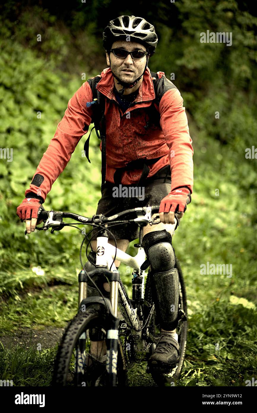 A portrait of a man mountain biking in the French Alps during the ...
