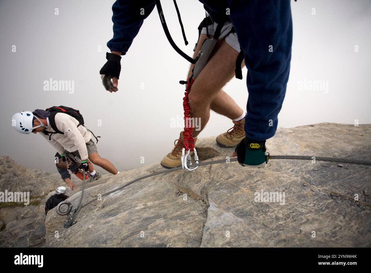 Four people climbing down the rock while engaging in the sport of Via ...