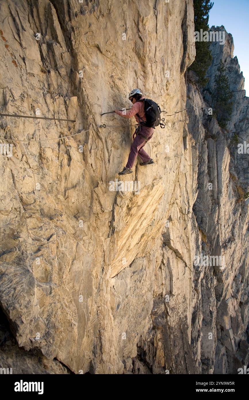 A young woman traverses a cliff while engaging in the sport of Via ...