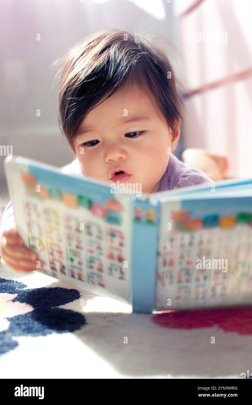 Baby with book in mouth hi-res stock photography and images - Alamy