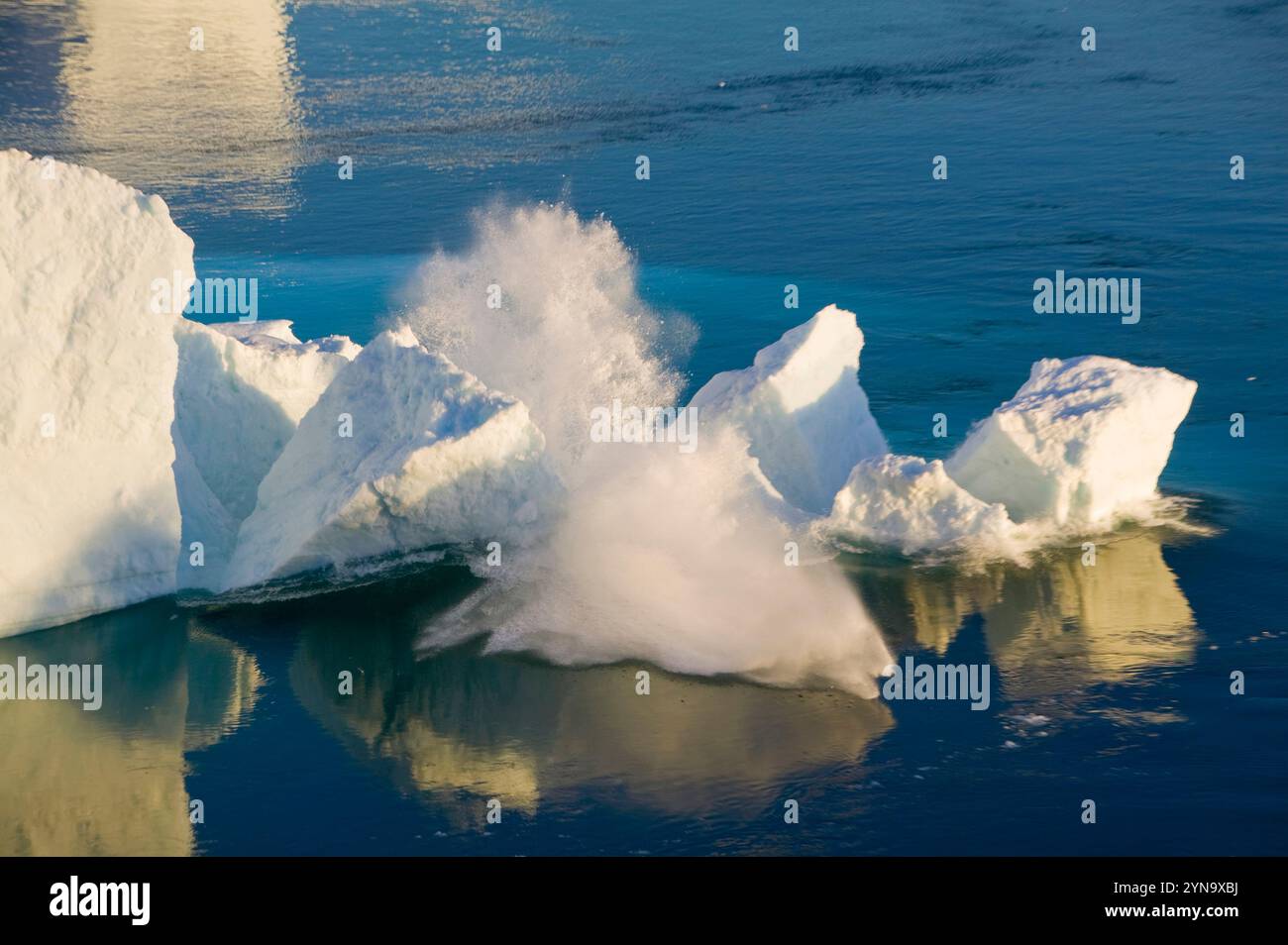 An arched Iceberg collapsing into the sea from the Jacobshavn glacier ...