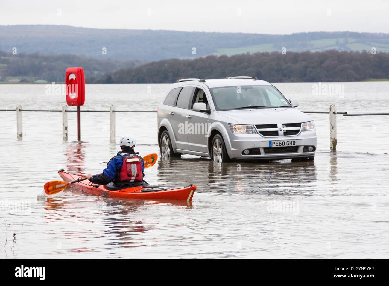 Kayaker and car in flooded street in Storth at Kent river estuary Stock ...