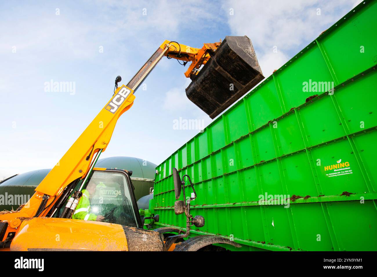 Bulldozer loading organic waste into tank at anaerobic bio digester ...
