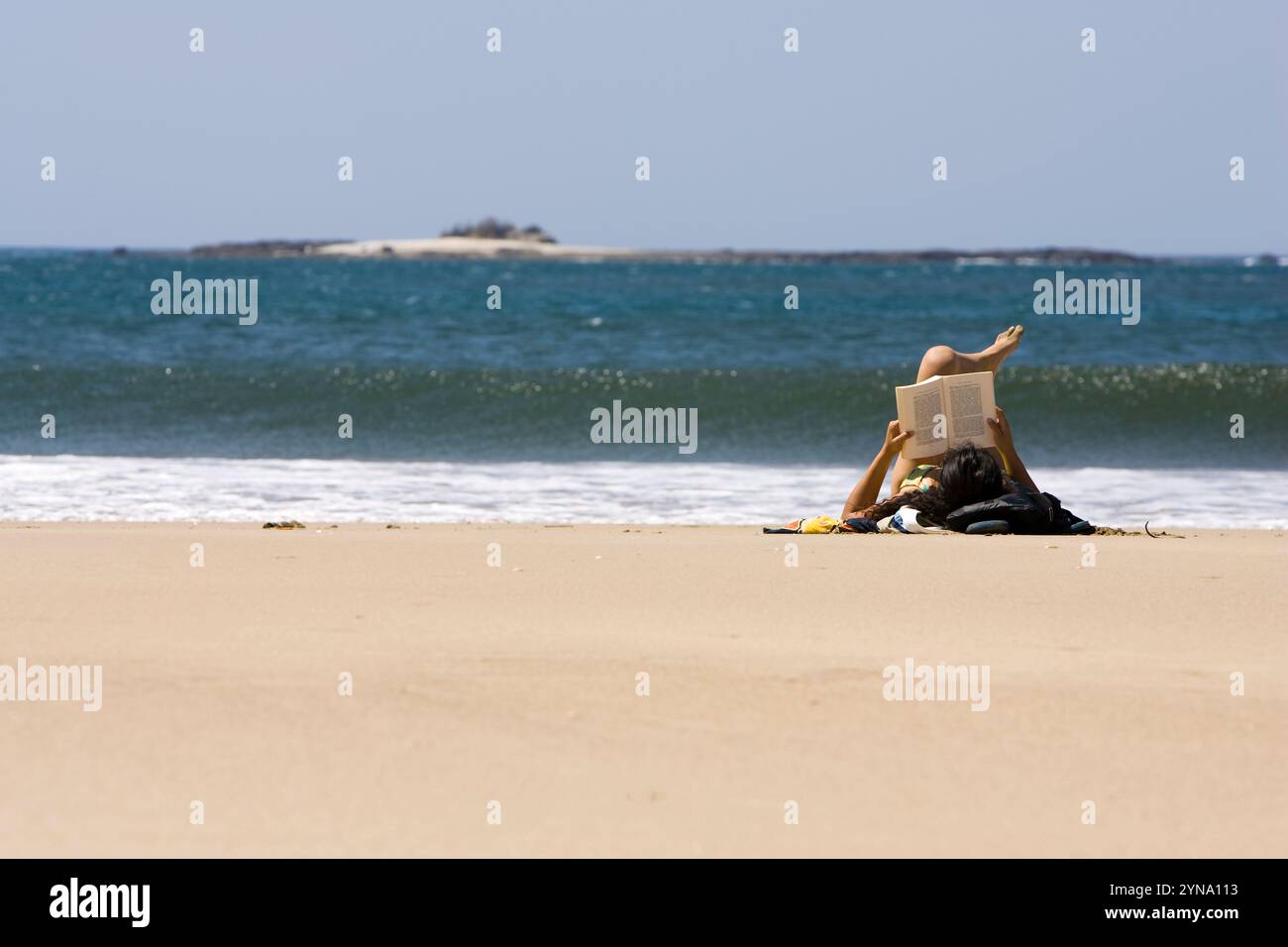 Reading alone on the beach Stock Photo - Alamy
